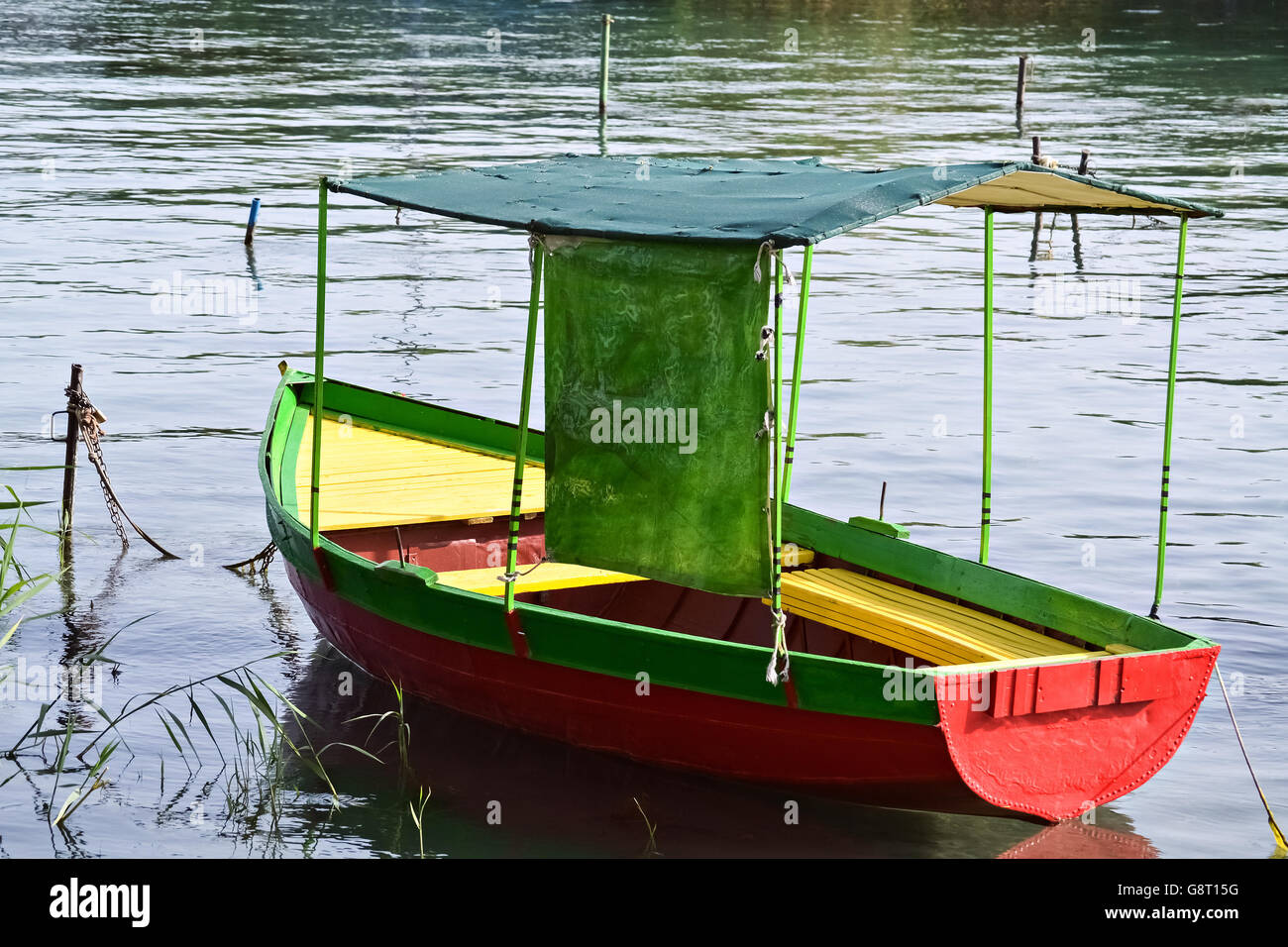 Closeup of a floating colorful rowboat anchored on the pier Stock Photo ...