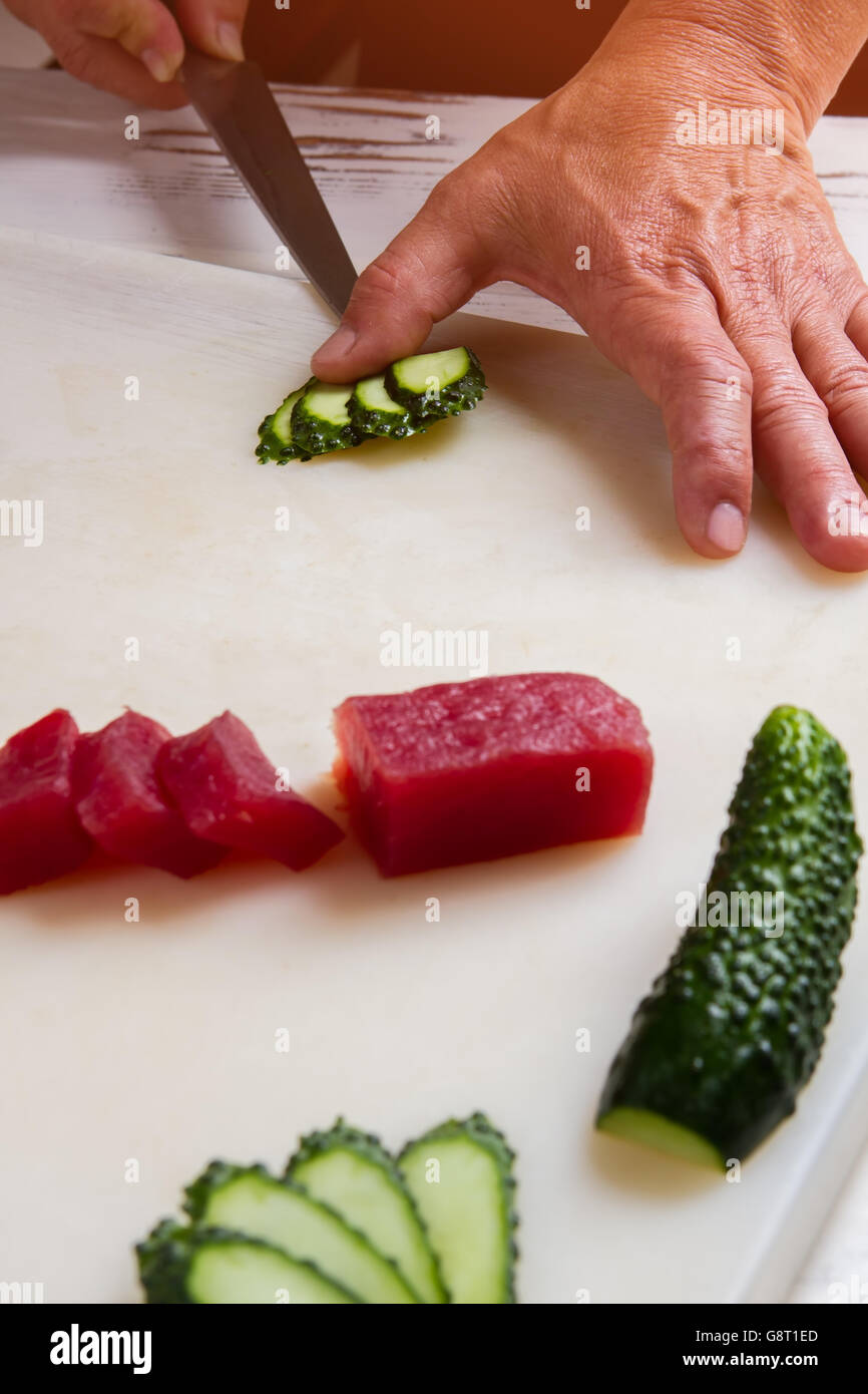 Hand with knife cutting cucumber Stock Photo - Alamy