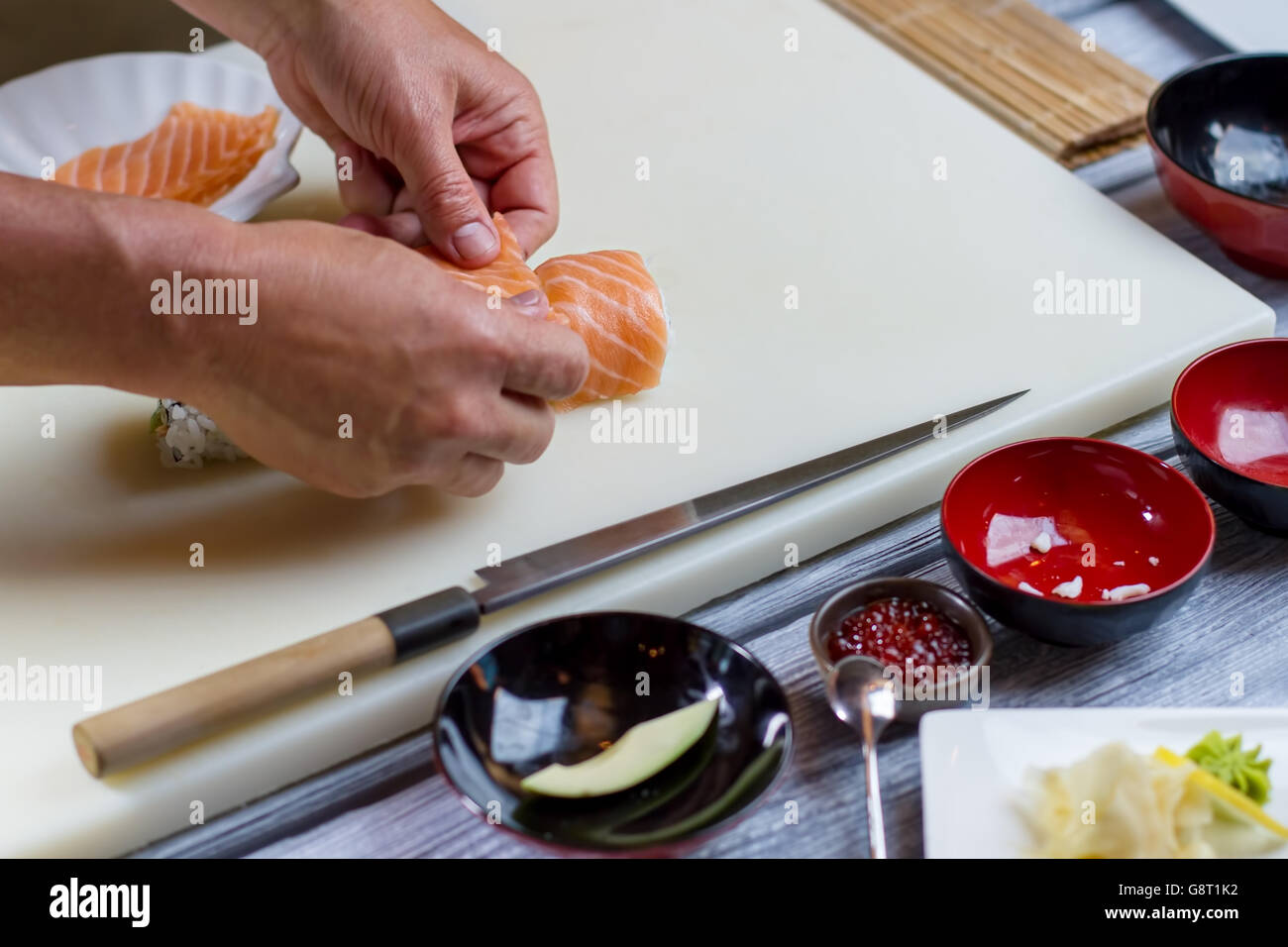 Man's hands over sushi roll Stock Photo - Alamy