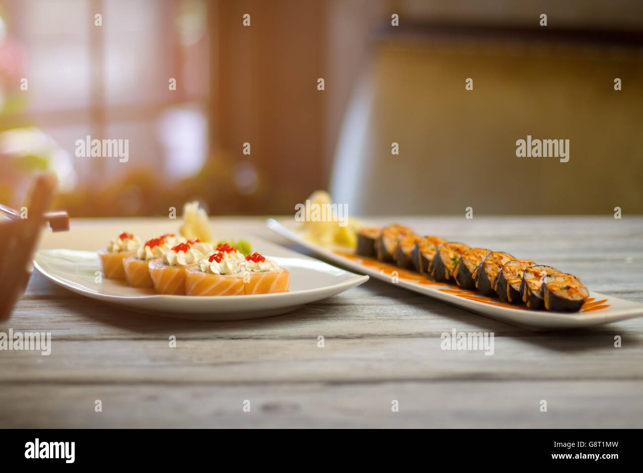 White plates with sushi rolls Stock Photo - Alamy