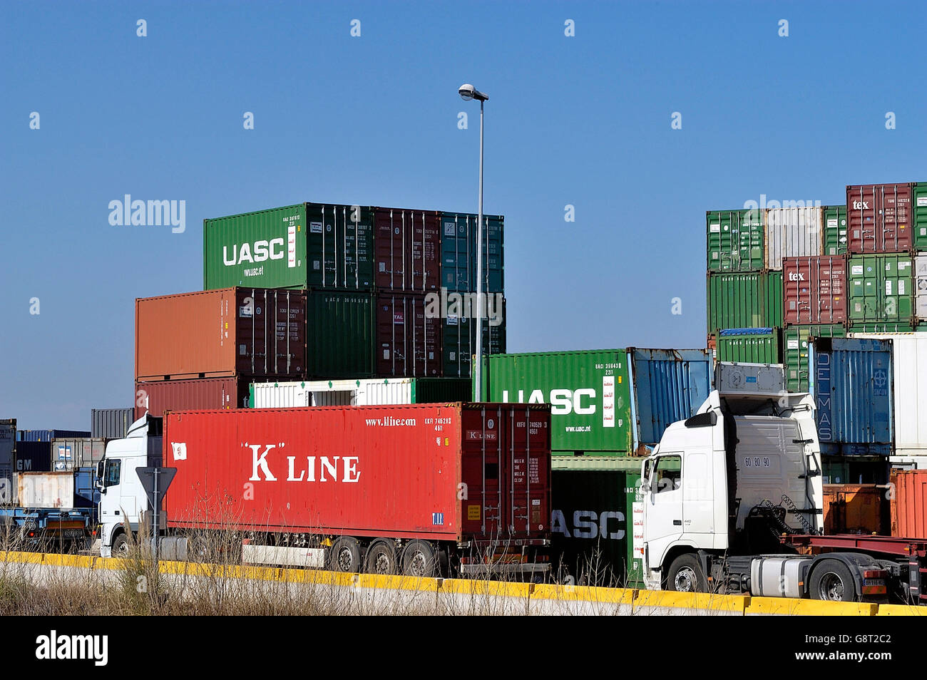 Trucks moving the containers to bring them to the quay of loading to be ...