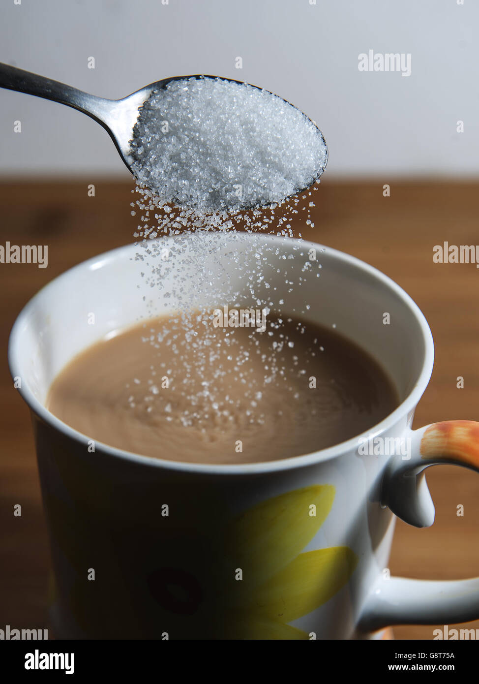 Tea stock. Sugar is poured into a cup of tea Stock Photo - Alamy