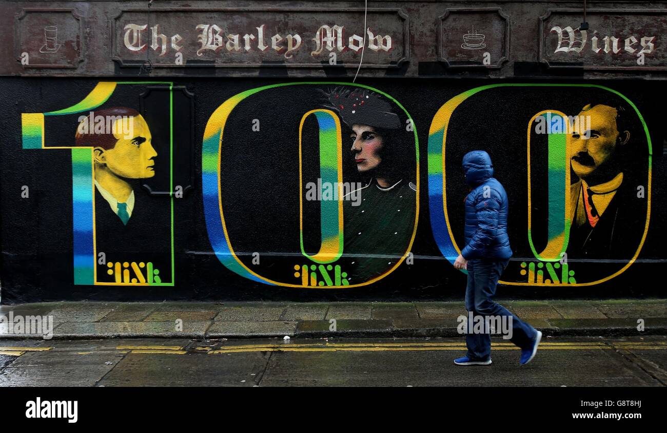 A man passes a mural in central Dublin featuring (left to right ...