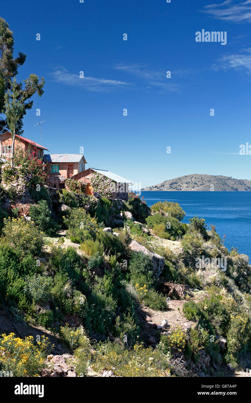 Houses, bush-covered ridge and lake, Capachica Peninsula, Lake Titicaca ...