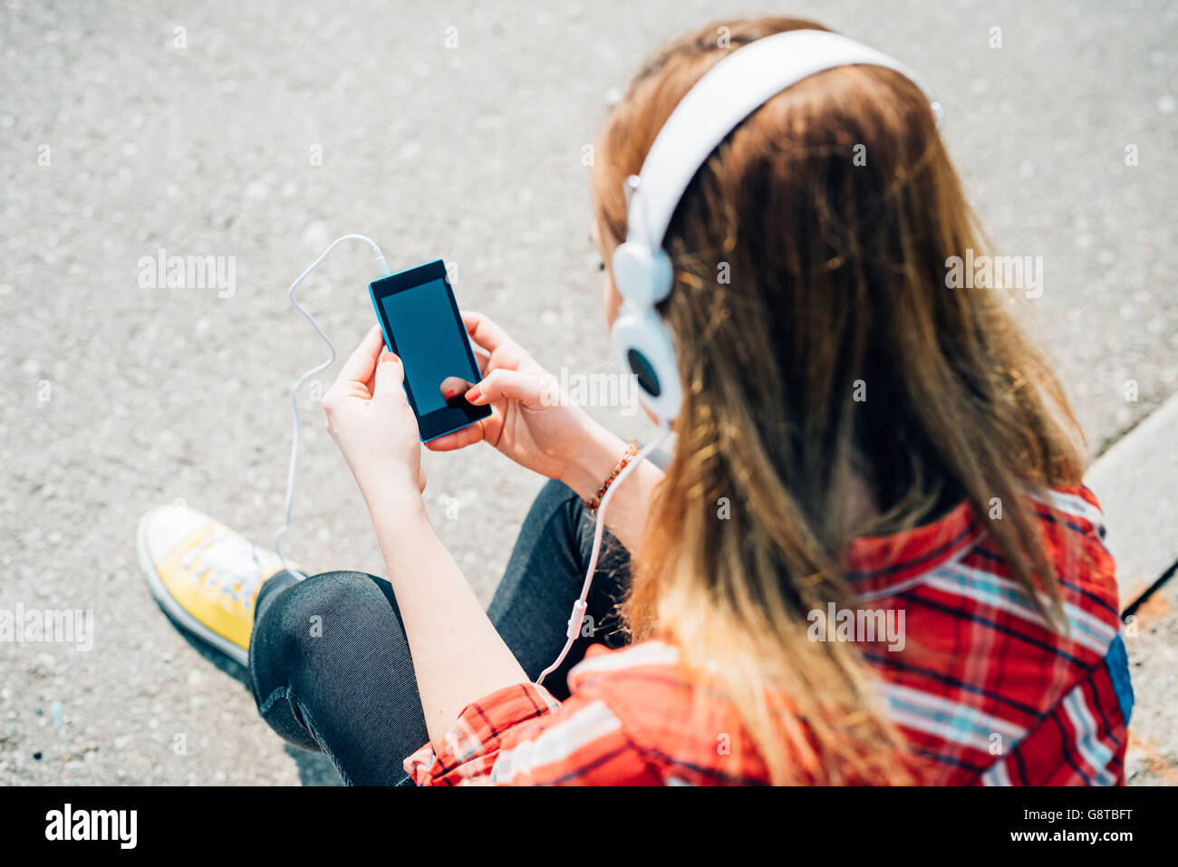 Back view of young beautiful caucasian blonde hair woman listening ...