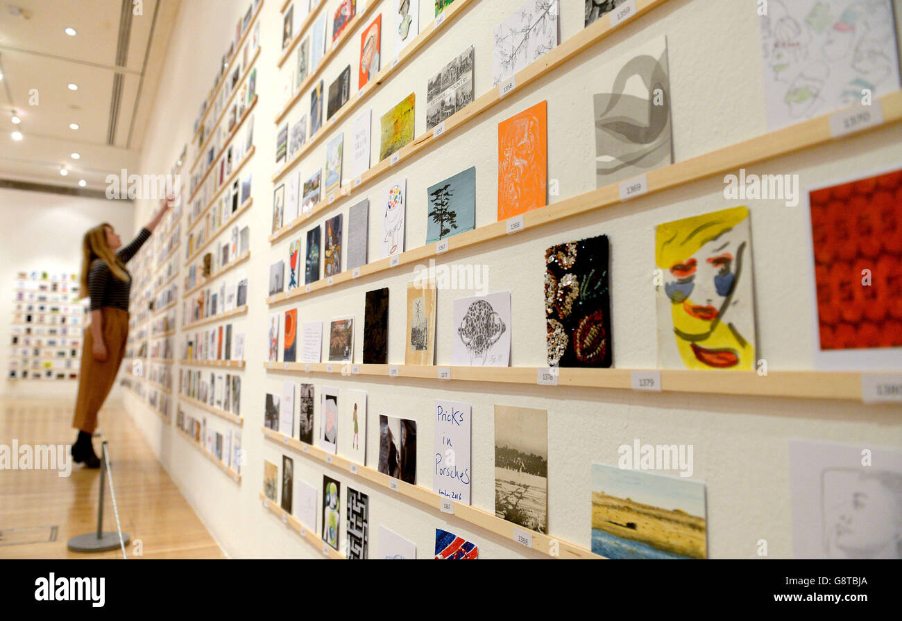A gallery worker looks at postcards during the press preview for the ...