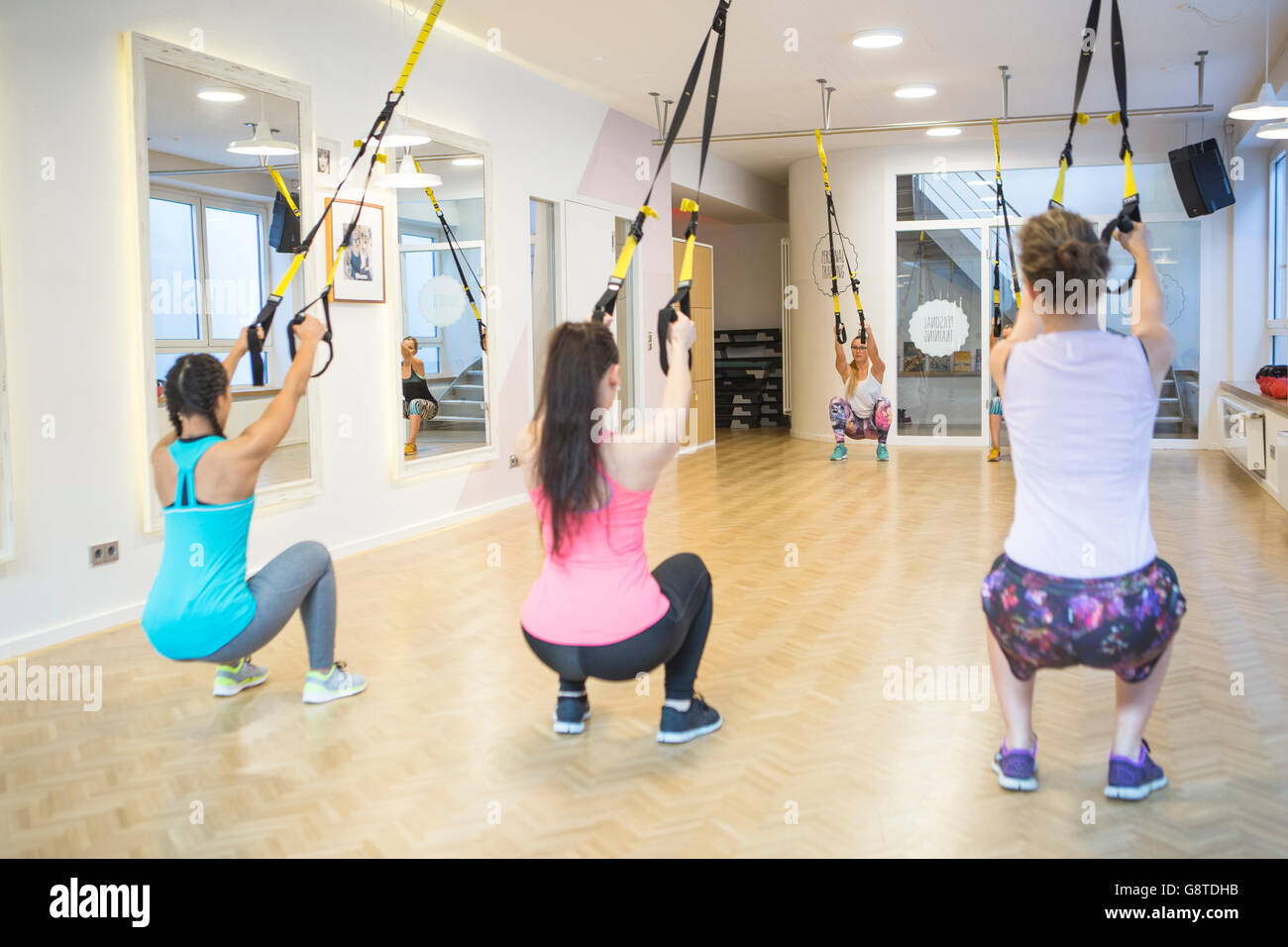 Women in exercise class doing suspension training Stock Photo - Alamy