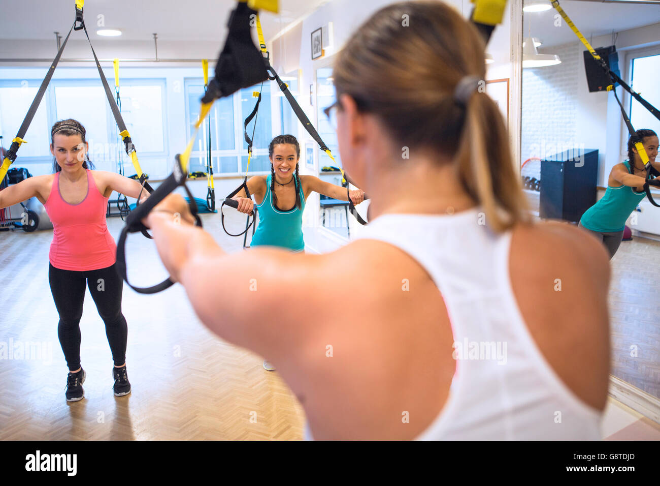 Women in exercise class doing suspension training Stock Photo - Alamy