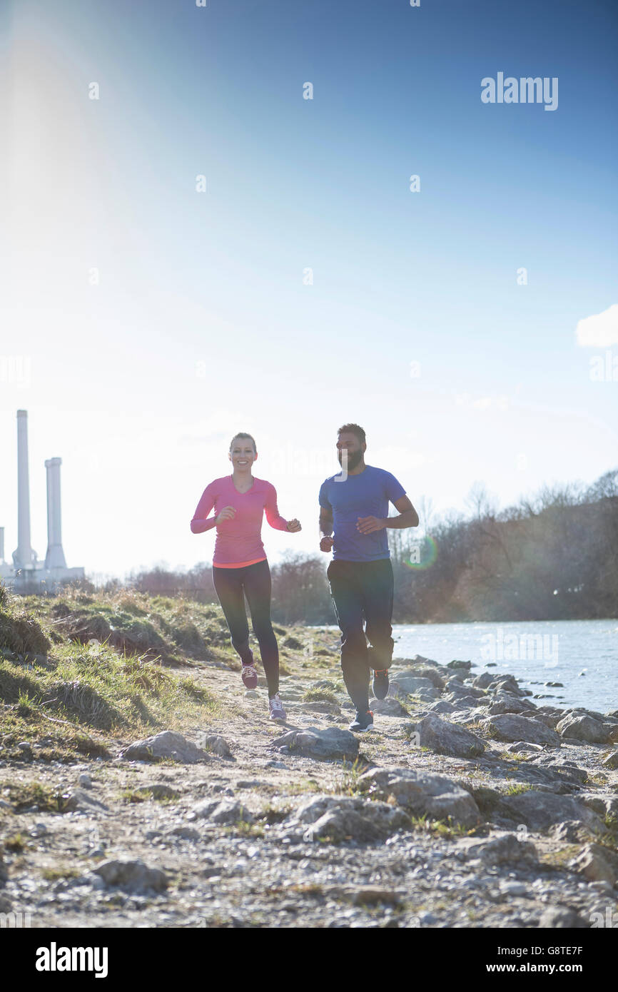 Young couple jogging by the riverside Stock Photo - Alamy