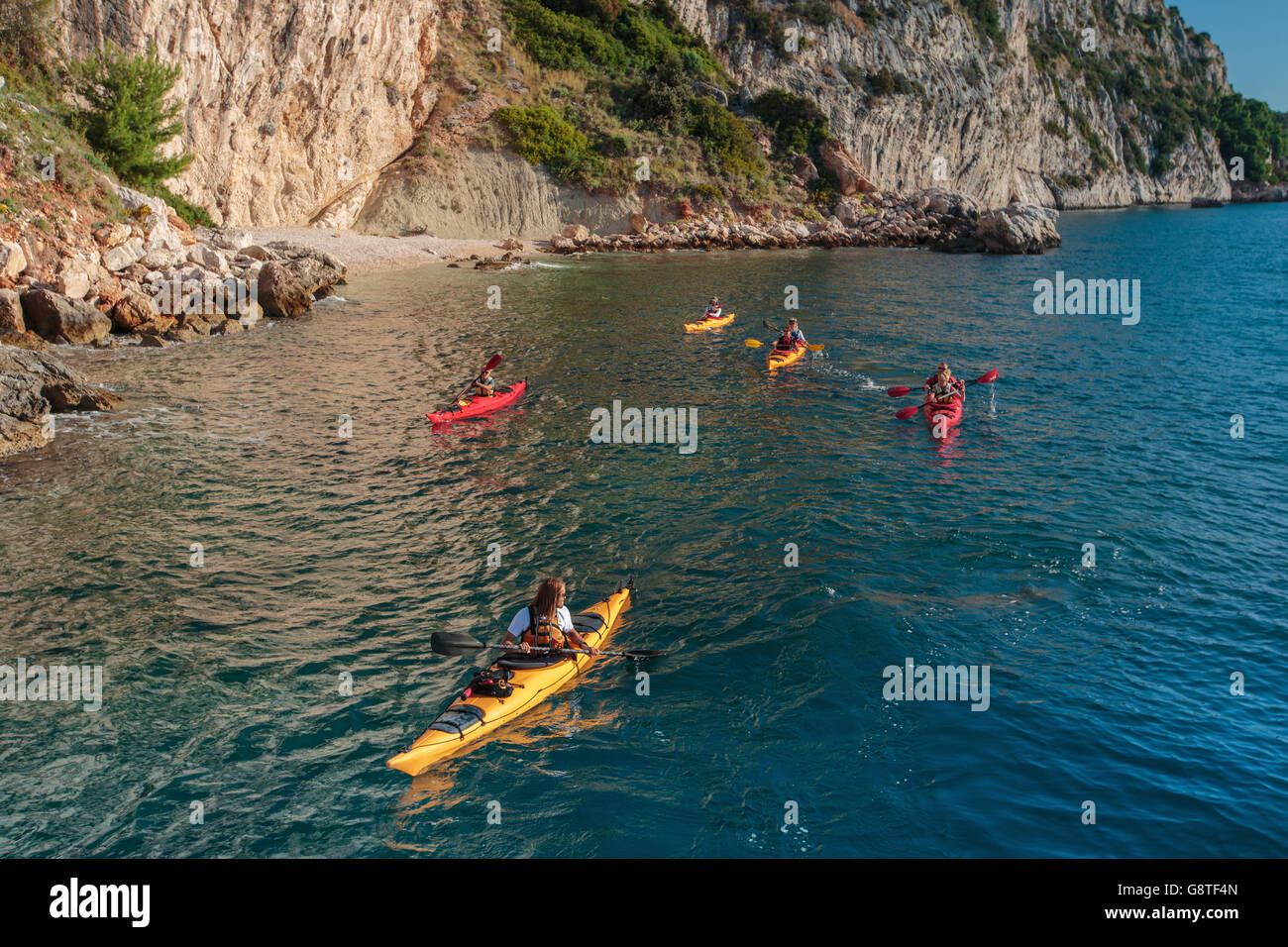 Group of people kayaking next to rock formation Stock Photo - Alamy