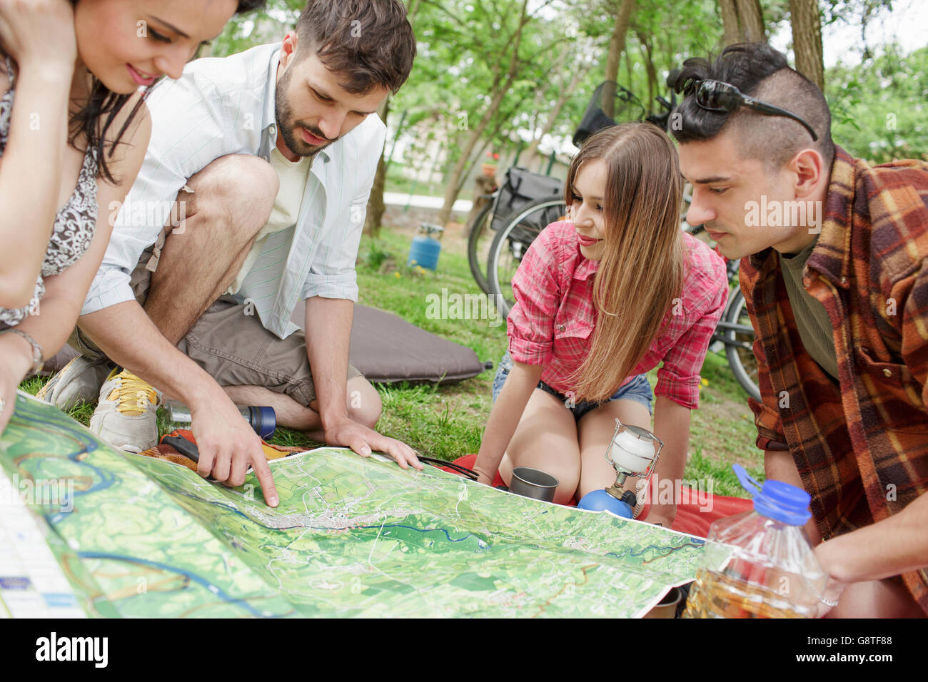 Group of friends reading map at campsite Stock Photo - Alamy