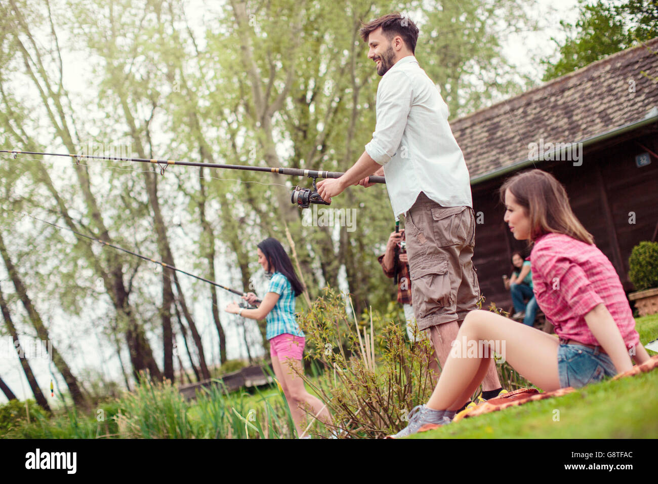 Group of friends fishing in lake Stock Photo - Alamy