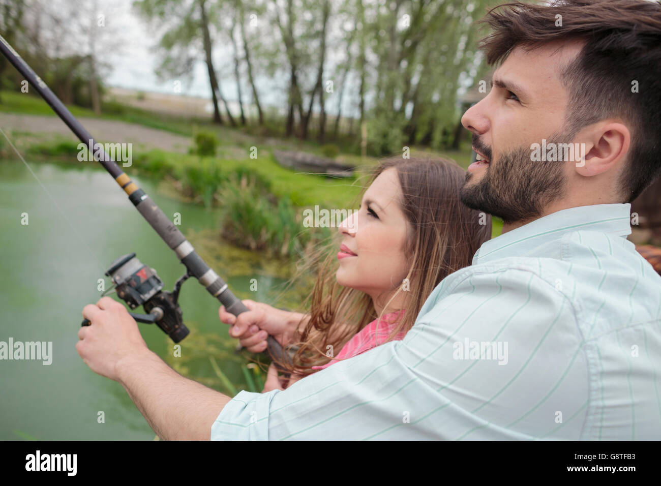 Young couple fishing together in lake Stock Photo - Alamy