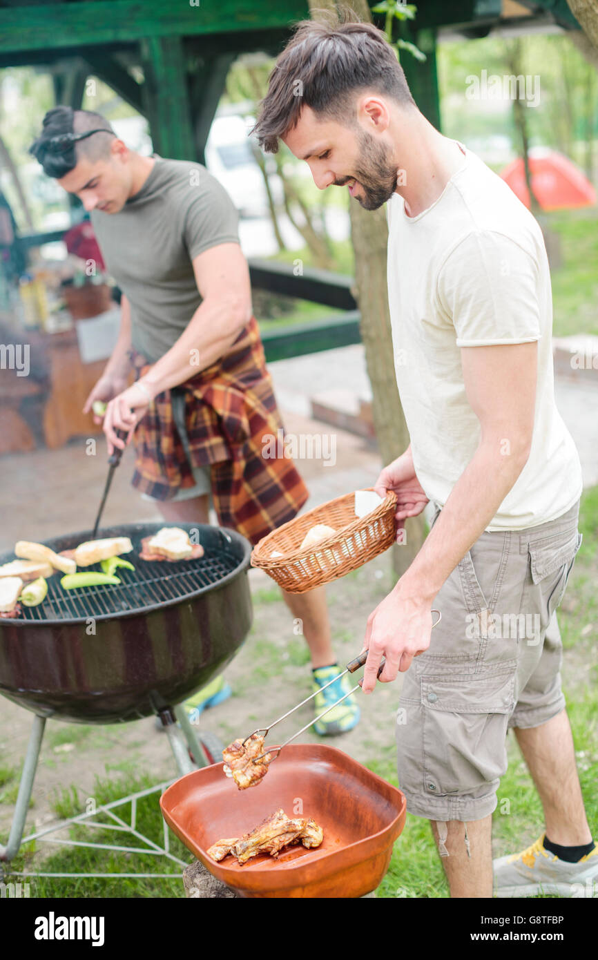 Group of friends having barbecue at campsite Stock Photo - Alamy