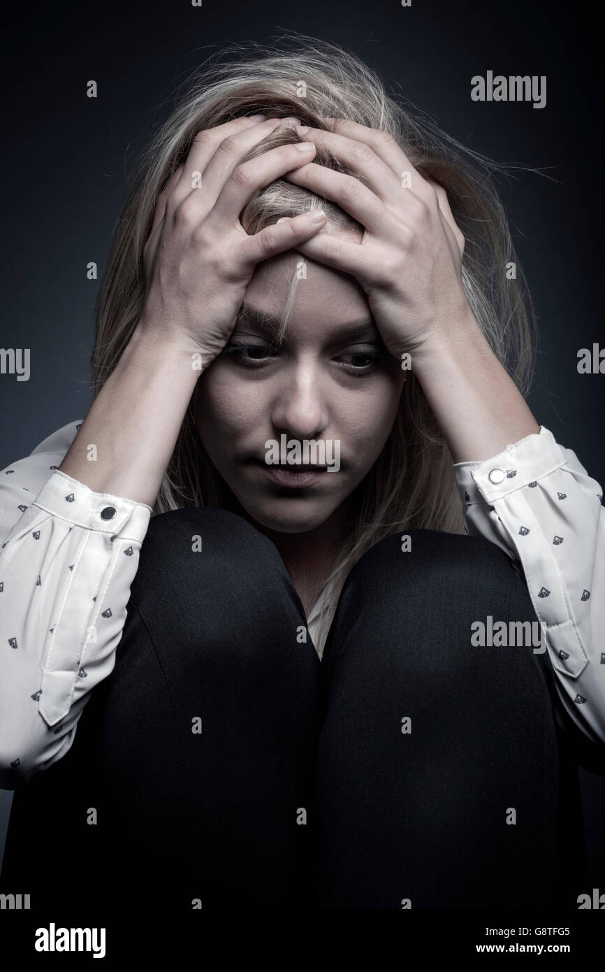 Young woman looking hopeless with head in hands Stock Photo - Alamy