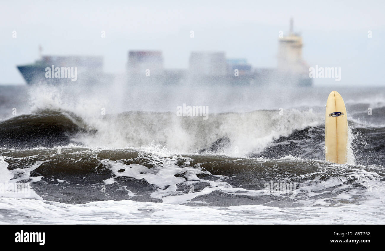 A surfer rides the waves at Tynemouth, Tyne and Wear, North Tyneside ...