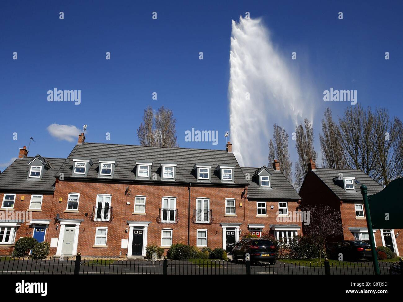 A burst water main on a building site sprays water reaching heights of ...