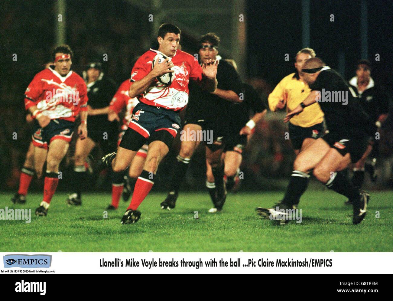 Llanelli's Mike Voyle (centre) runs at the New Zealand defence Stock ...