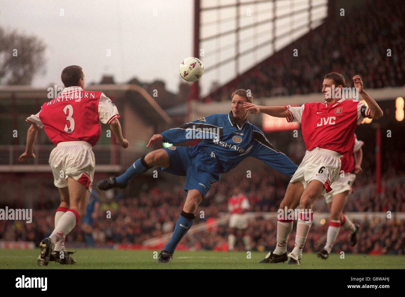 Nigel Winterburn (left) and Tony Adams (right) of Arsenal watch as ...