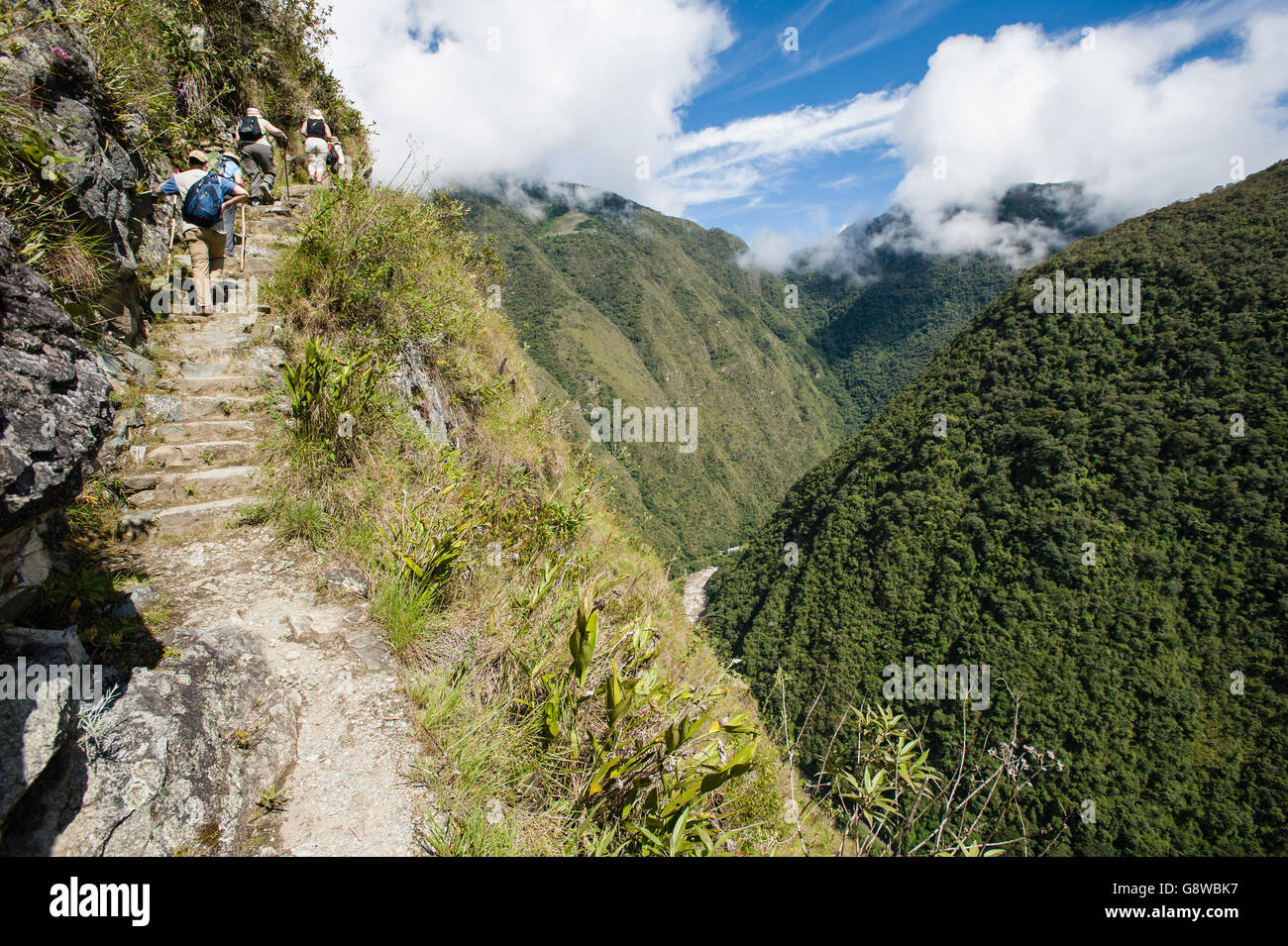 Hikers walking up the Inca Trail along a ridge leading to Machu Picchu ...