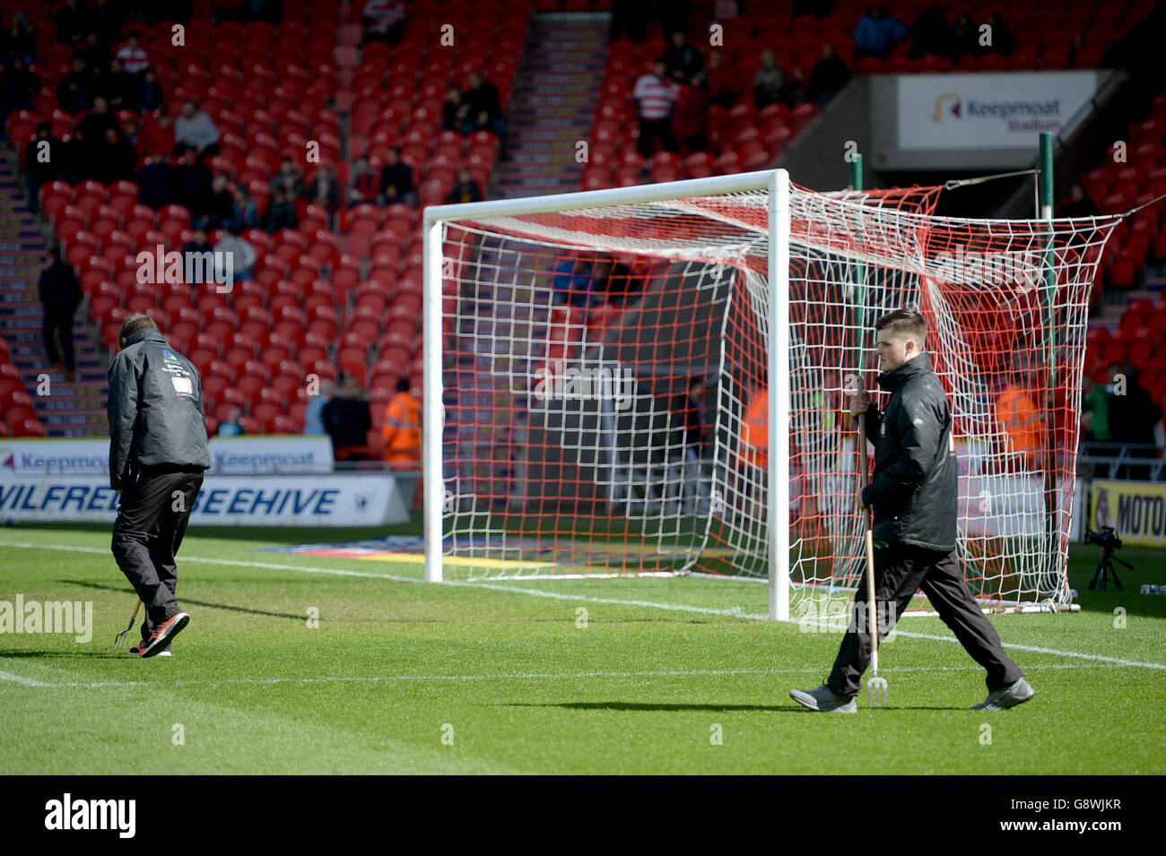 Doncaster Rovers groundsmen work on the pitch before the game Stock ...