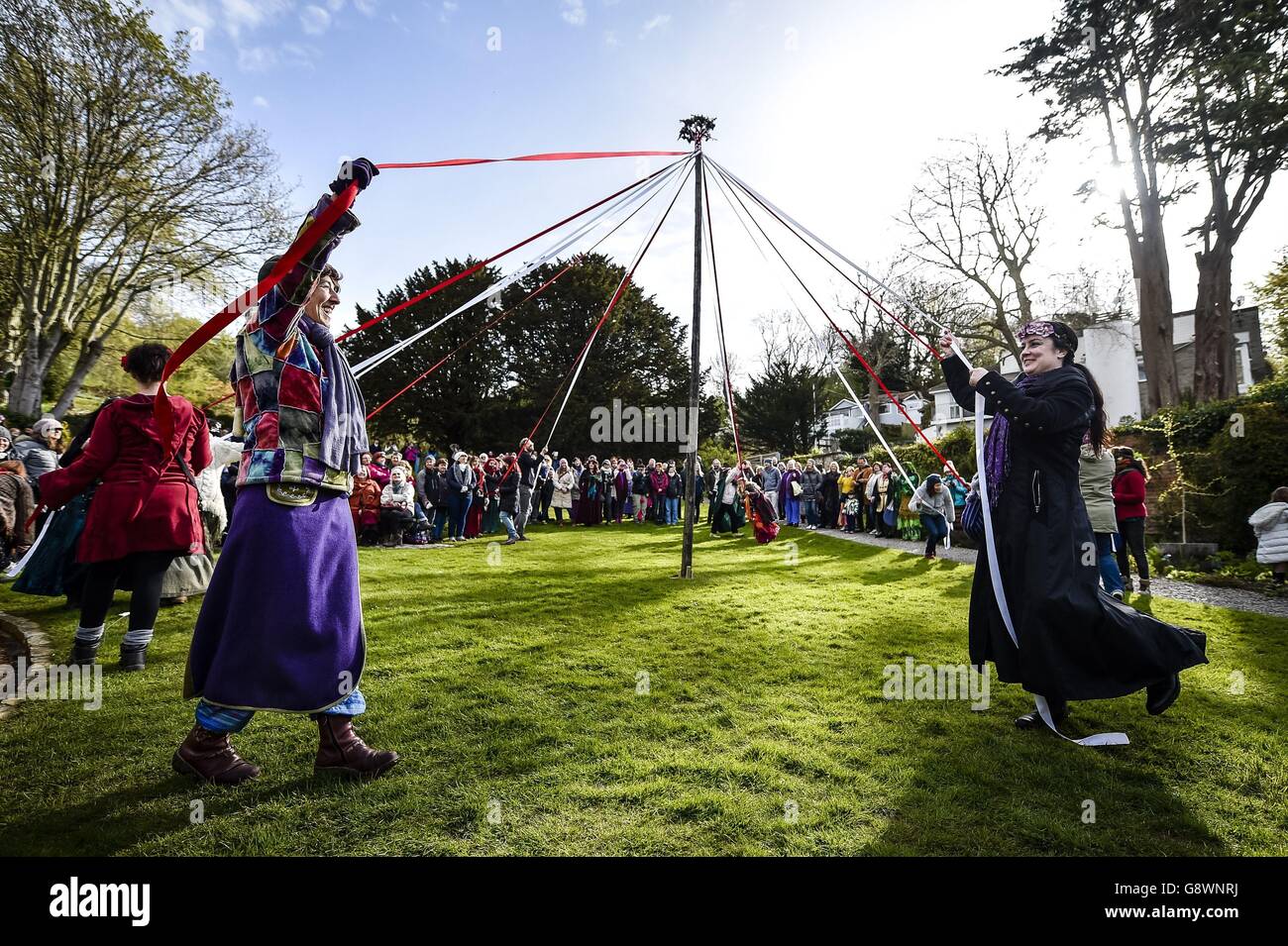 People take part in the traditional maypole dance in the Chalice Well, Glastonbury, where ...