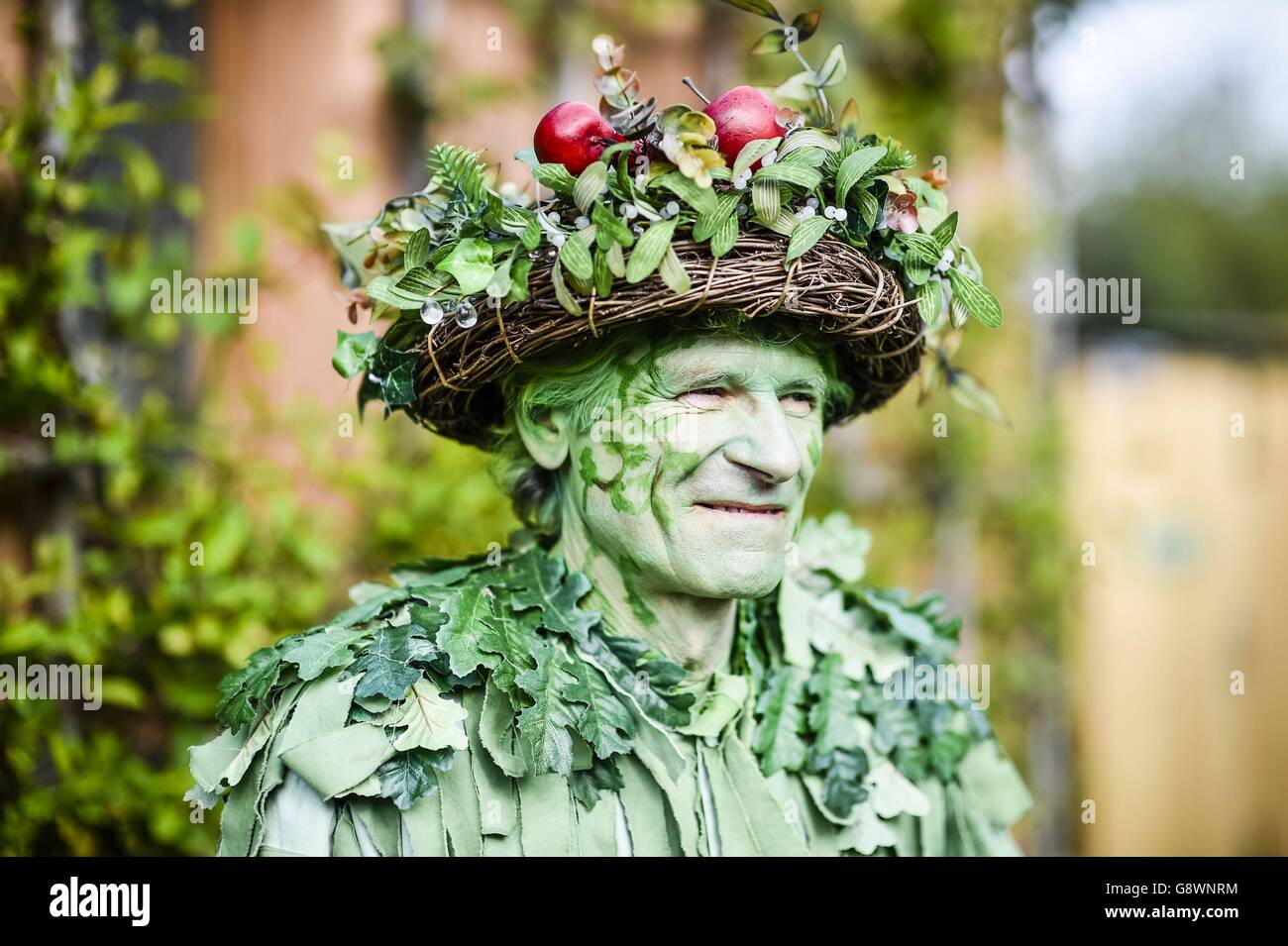 A man dressed in leaves watches the traditional maypole dance in the ...