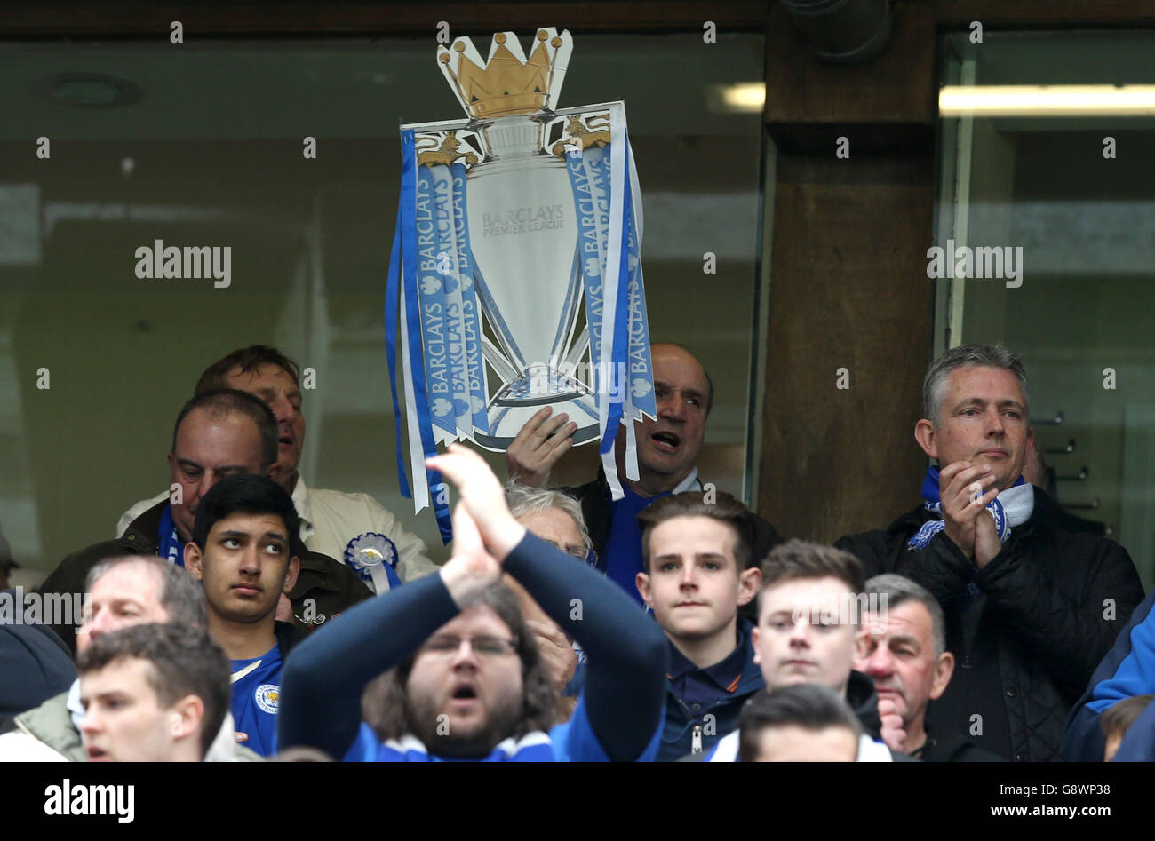 A Leicester City fan waving a cardboard Premier League trophy in the ...
