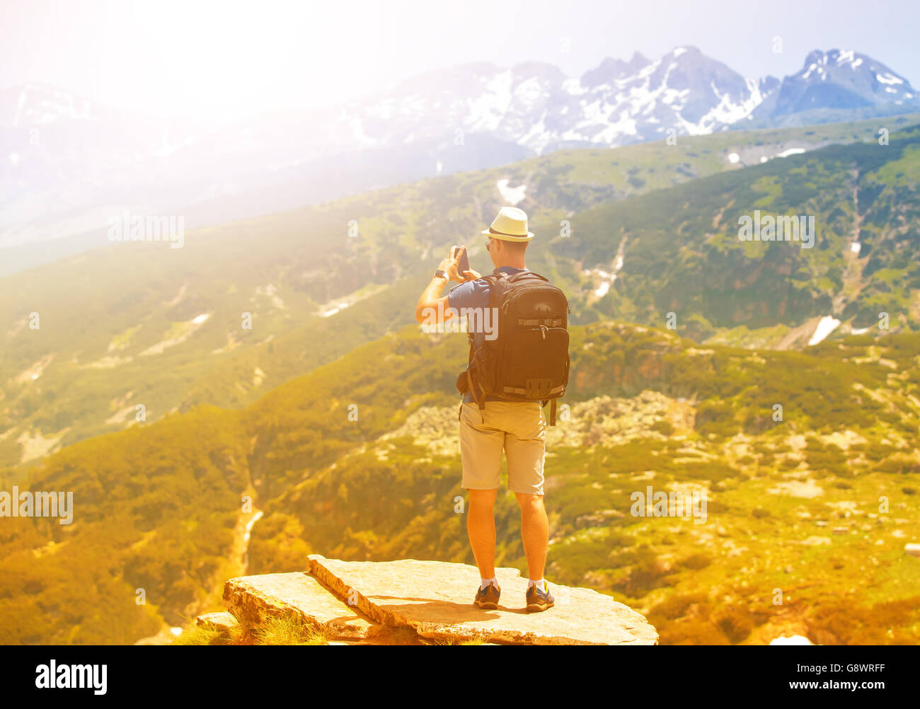 Hiker taking photo of beautiful mountain landscape Stock Photo - Alamy