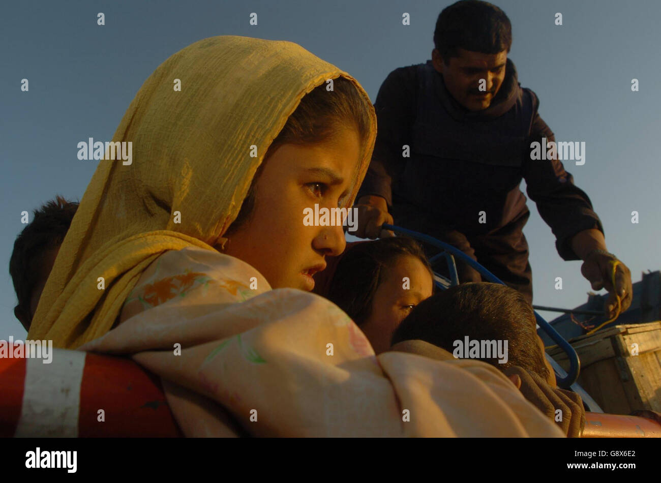 A young Pakistani girl looks on as an anti-narcotics officer searches ...