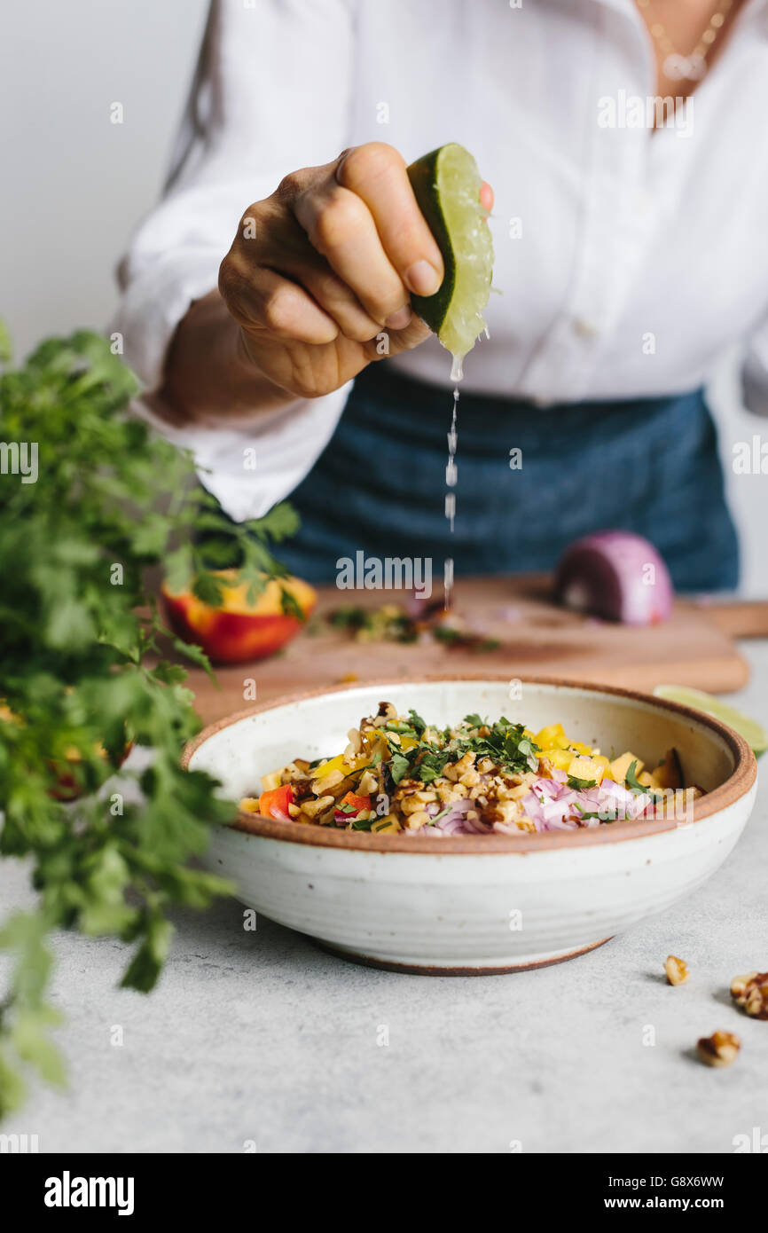 A woman is photographed while she was squeezing lime into a bowl of ...