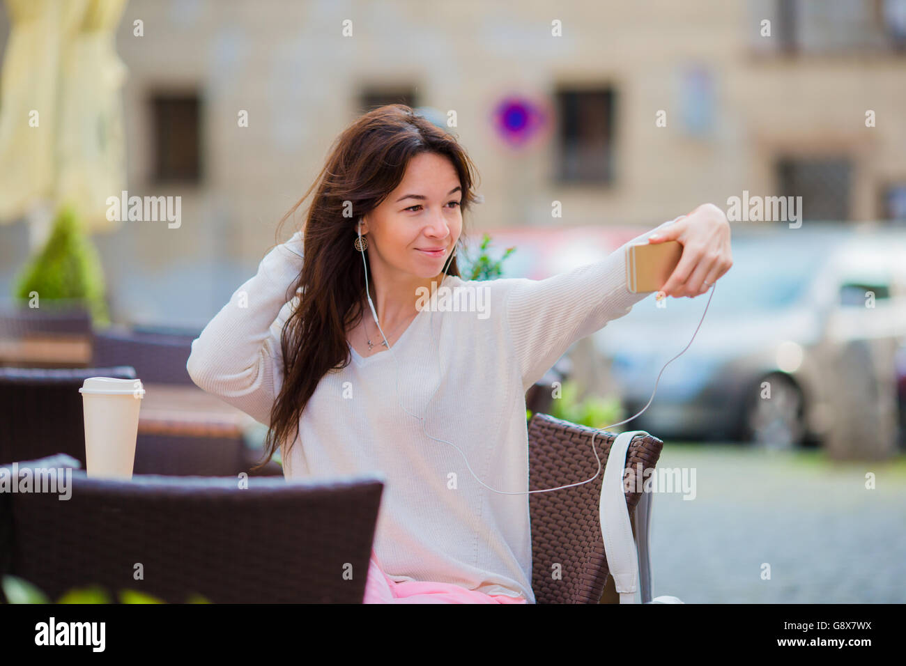 Young caucasian woman sending message and taking self portrait in ...