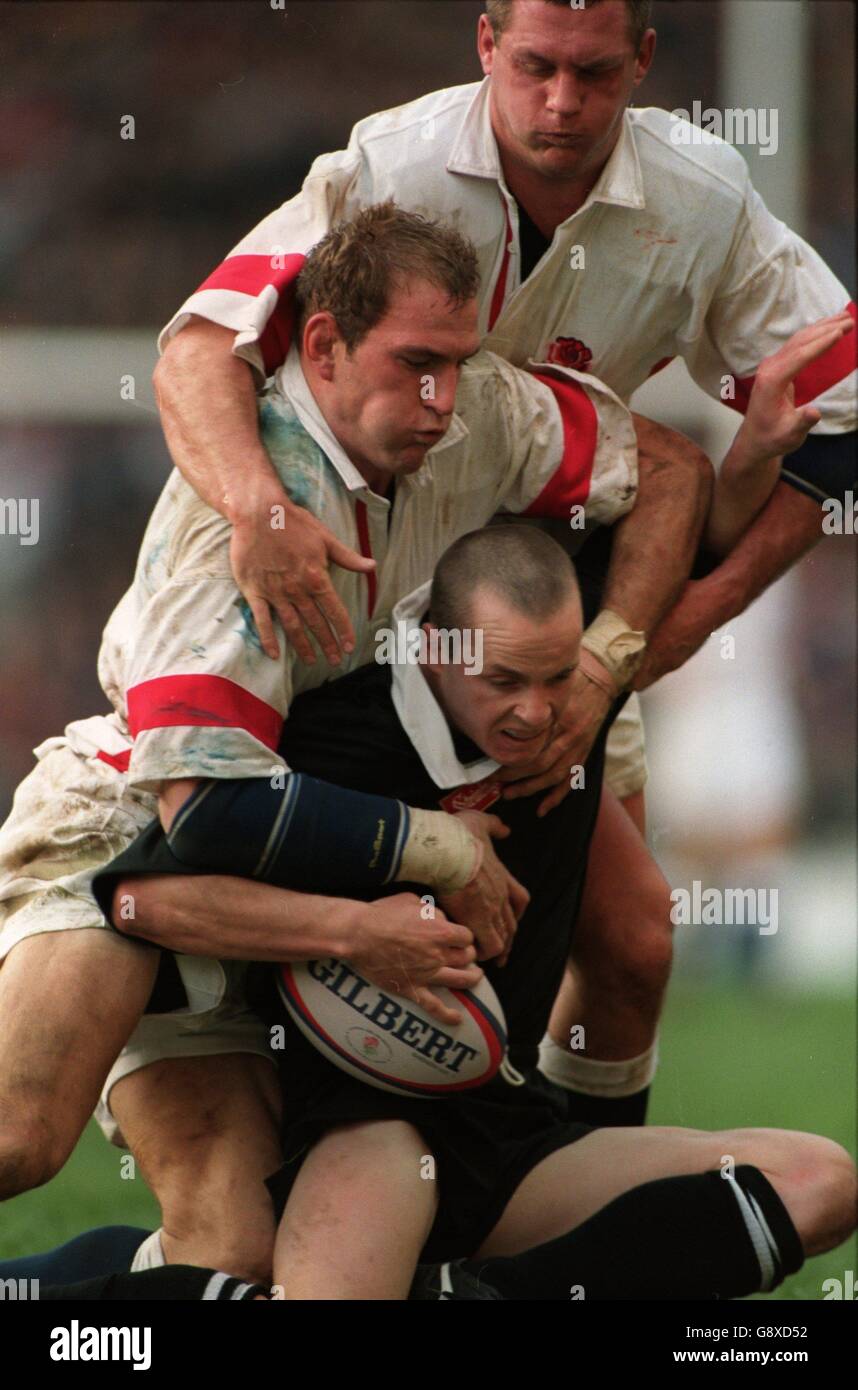 Christian Cullen of New Zealand (bottom) is tackled by England's ...