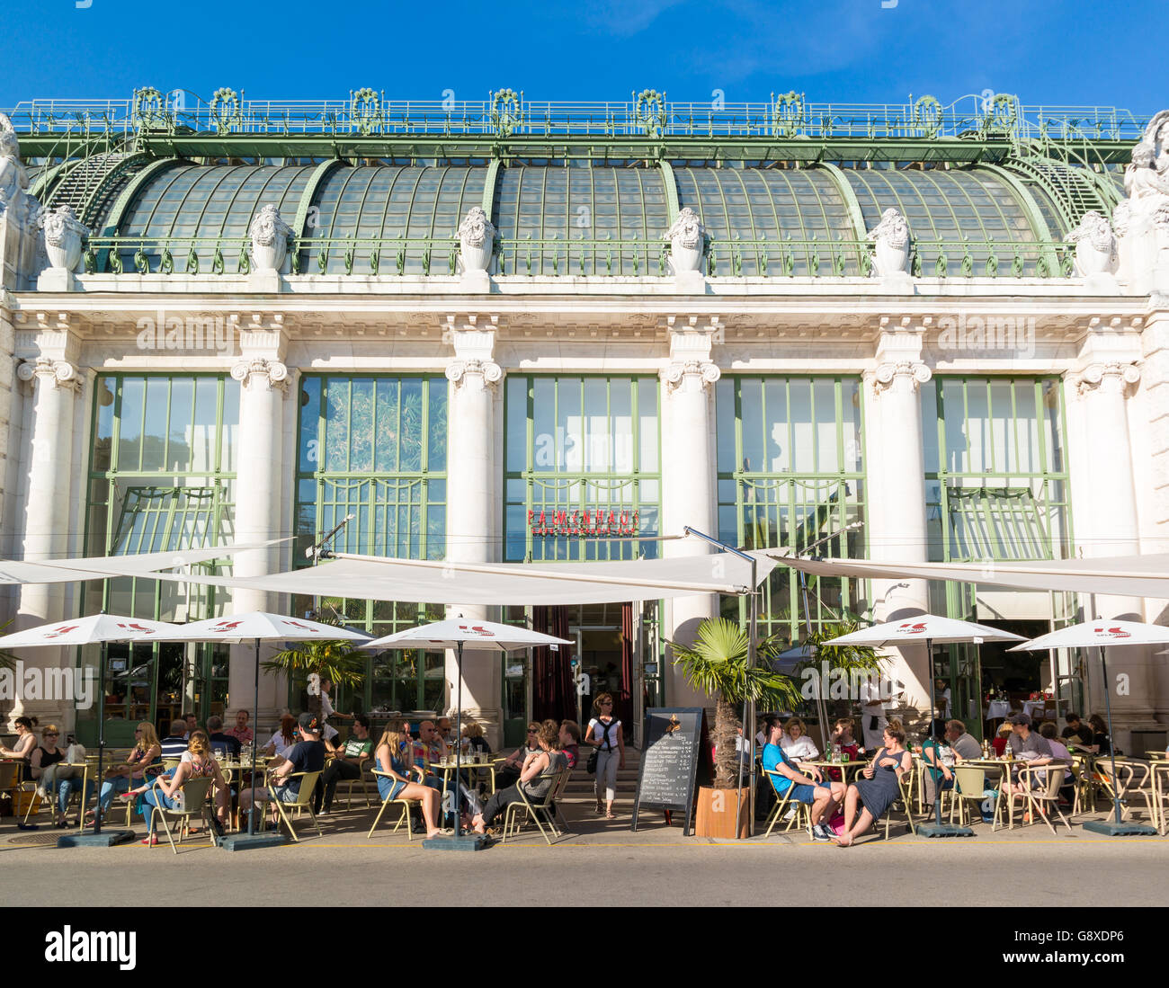Outdoor terrace of Palm House cafe with people in Burggarten Gardens in ...