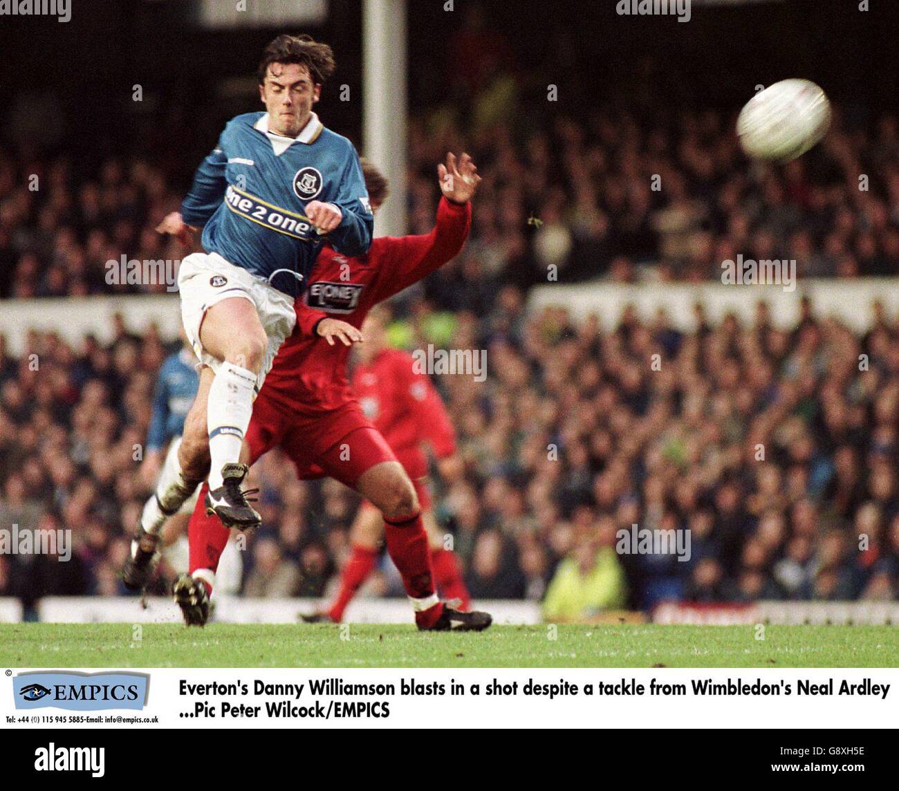 Everton's Danny Williamson (left) blasts in a shot despite a challenge ...