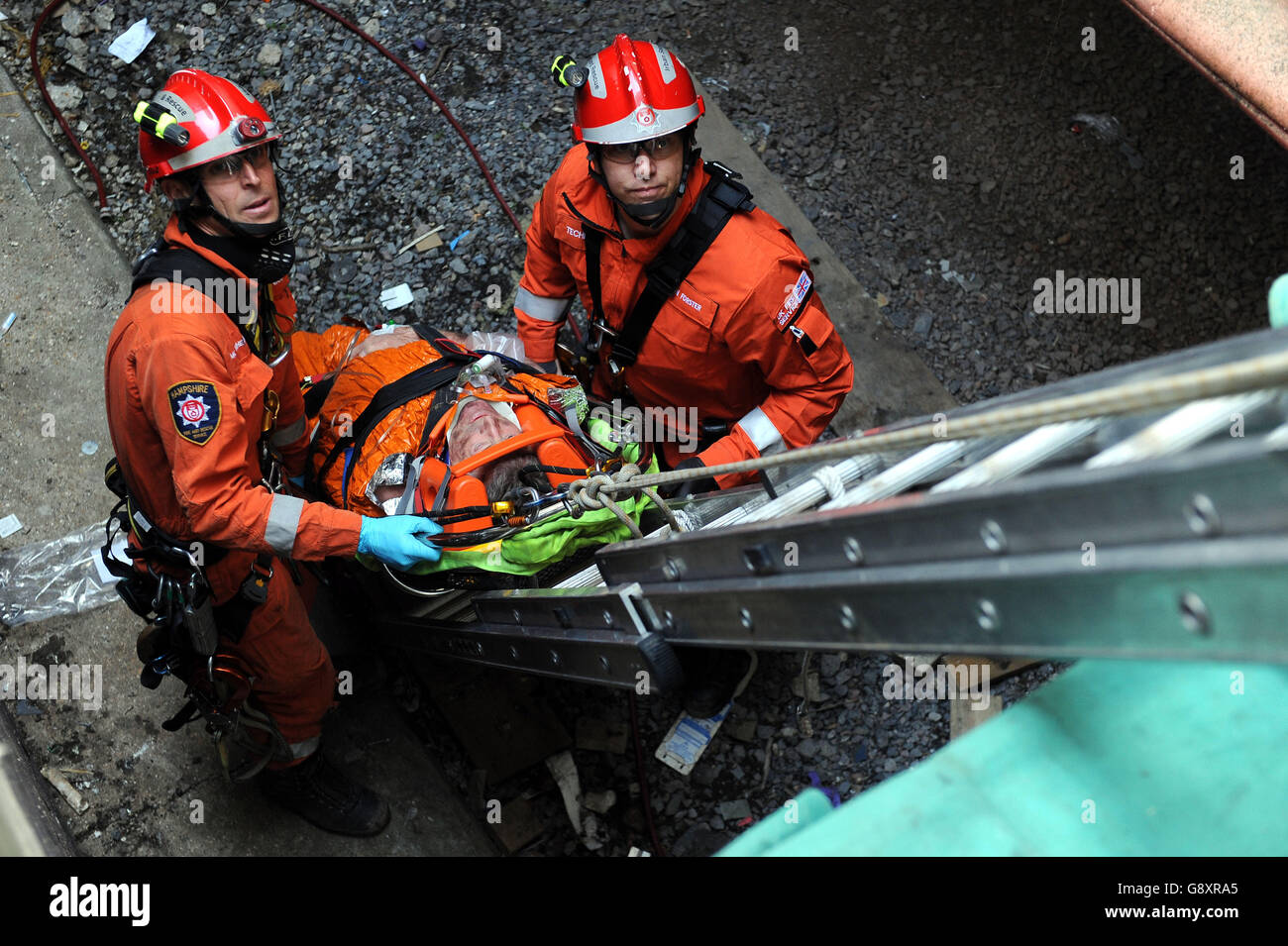 An actor on a stretcher is tended to by members of the Hampshire Fire ...