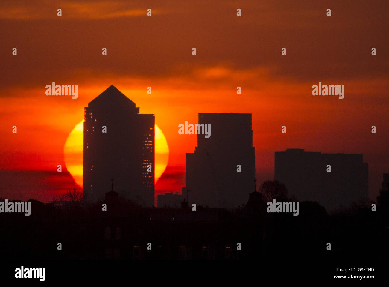 The early morning sun rises behind the Canary Wharf skyline from Tower ...