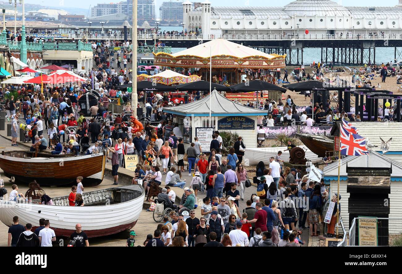 People walk along the promenade in brighton hi-res stock photography ...