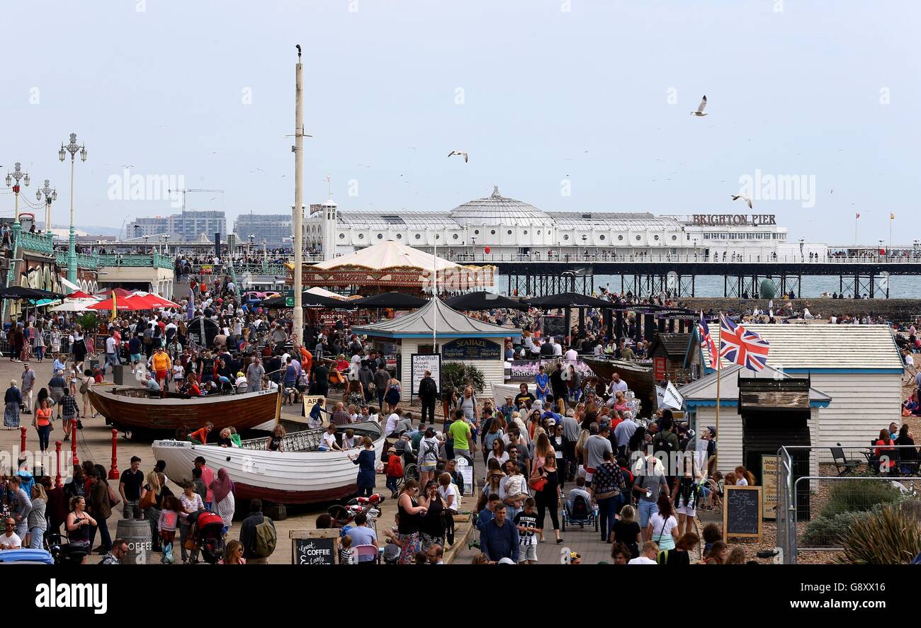 People walk along the promenade in Brighton, East Sussex, as parts of ...