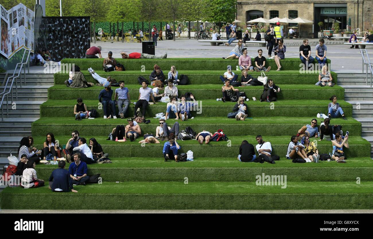 Visitors to Granary Square rest on steps by the Regents Canal towpath ...