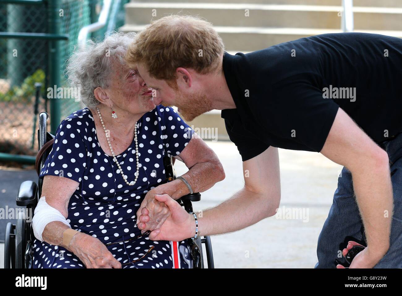 Prince Harry (right) receives a kiss from 91-year-old Ruth Uffelman ...