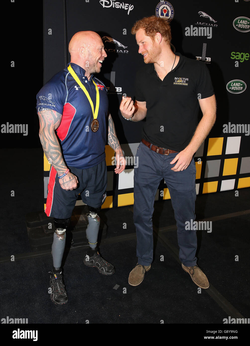 Prince Harry presents a gold medal to lightweight weightlifter Michael ...