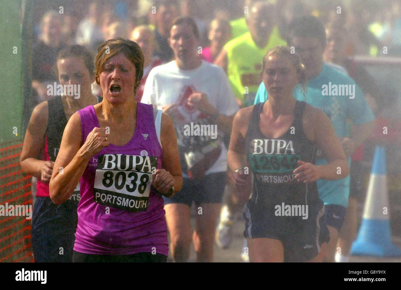 Runners pass through a 'shower' at the six and a half mile point during ...