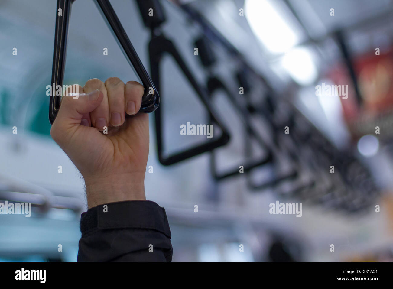 A hand grips one of the many handles on this Tokyo train Stock Photo ...