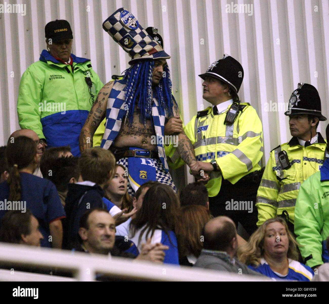 A Portsmouth fan is escorted away by police officers during the ...