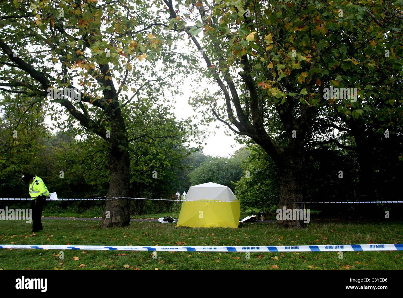 A policeman stands outside the forensic tent, marking the spot on ...
