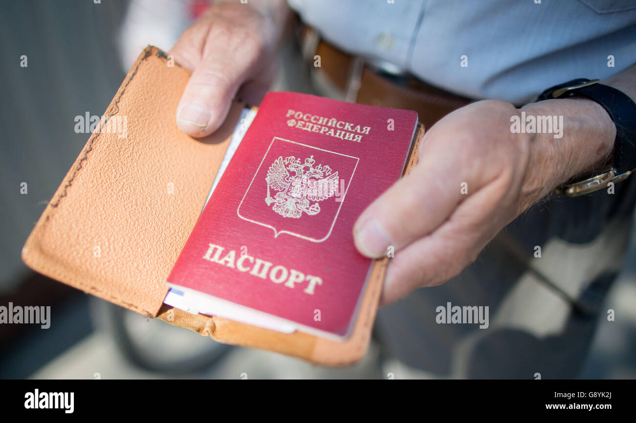 A man holds a Russian passport in his hands on the border to Russia in ...