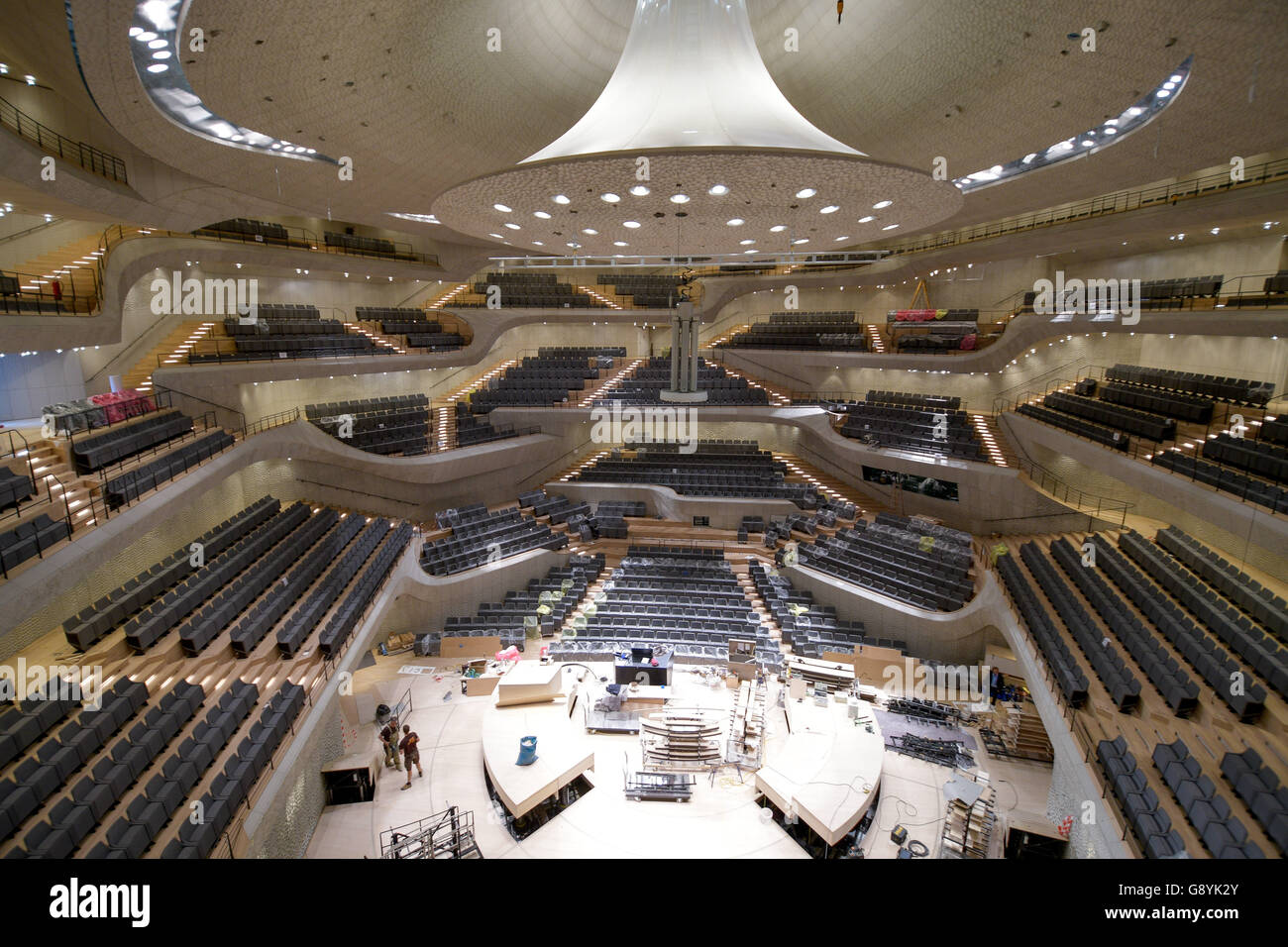 Technicians work in the great hall, in which seating and an organ are ...