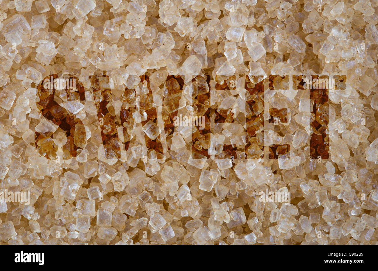 Sweet word screened on background of close focus brown cane sugar Stock ...
