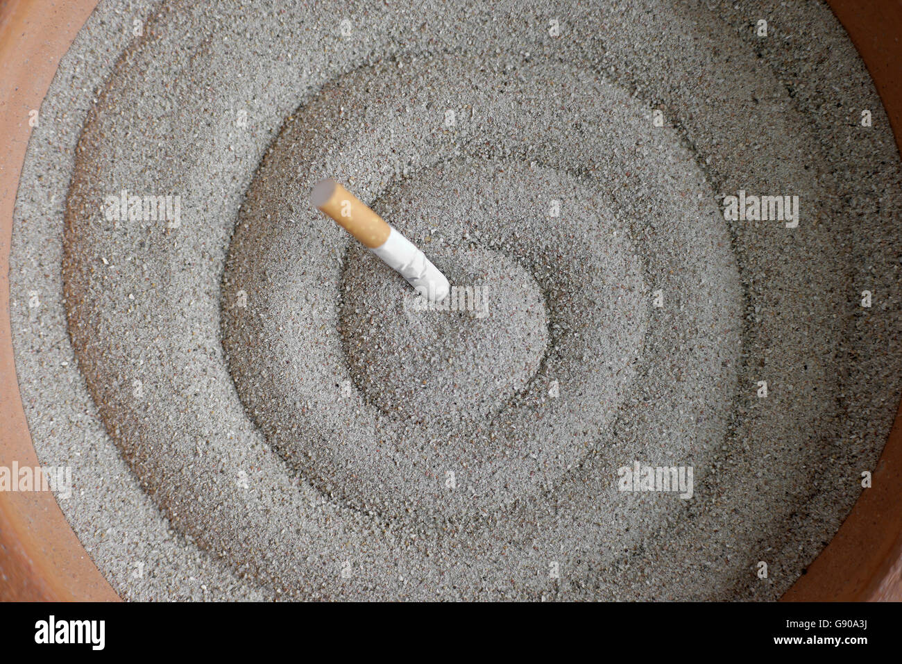 smoked cigarettes in sand ashtray Stock Photo - Alamy